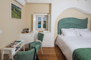 Quarto com cama, escrivaninha, cadeira e janela.