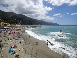 Na praia, areia preta, prática de mergulho livre no local 