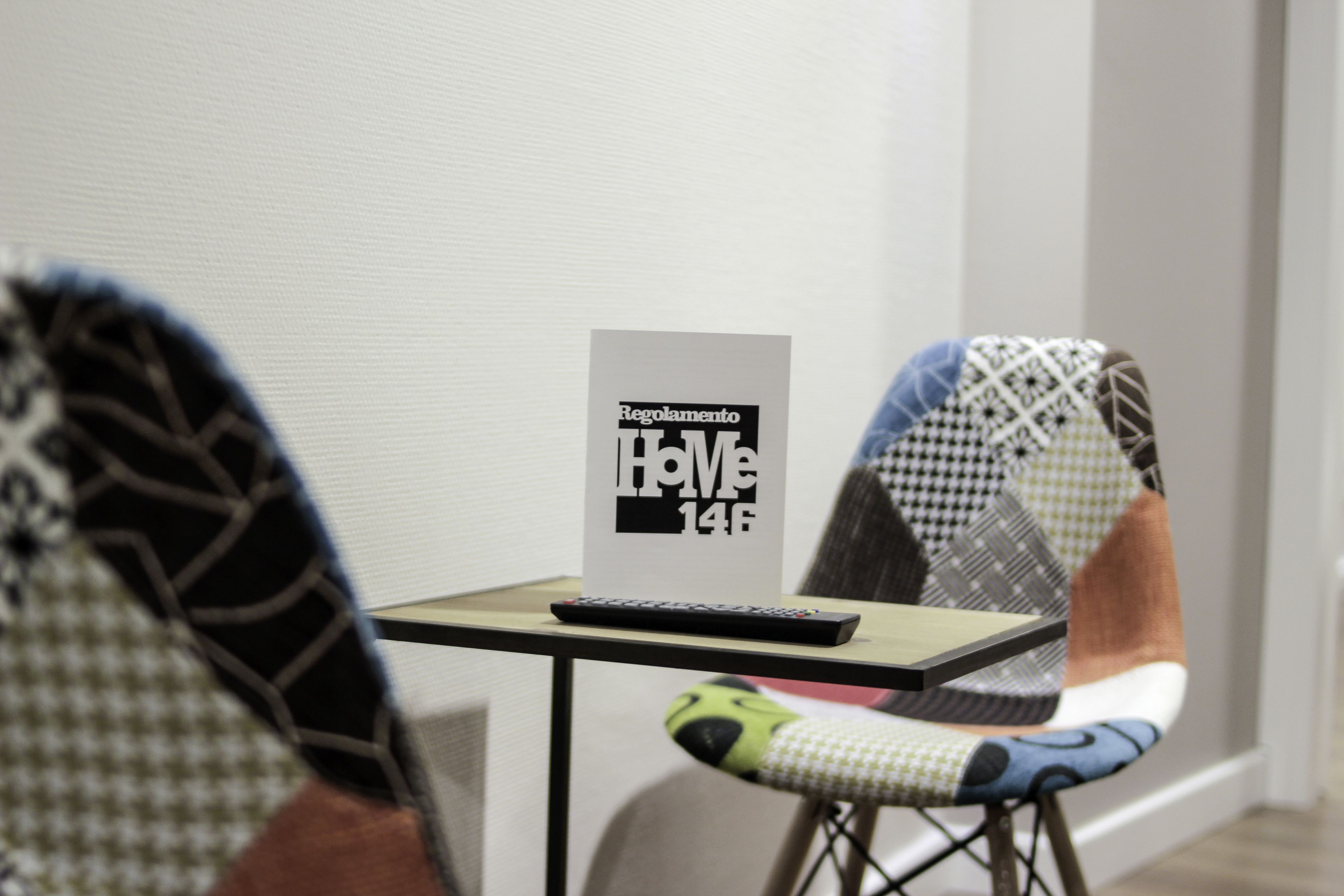 Uma cadeira com almofada estampada e uma placa sobre a mesa.