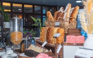 Vitrine de uma padaria com diversos tipos de pães e doces.