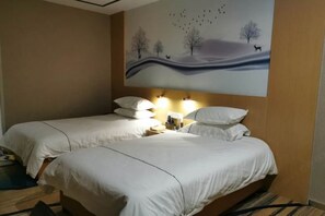 Quarto de hotel com duas camas, uma mesinha de cabeceira com luminárias e um mural na parede retratando uma paisagem.