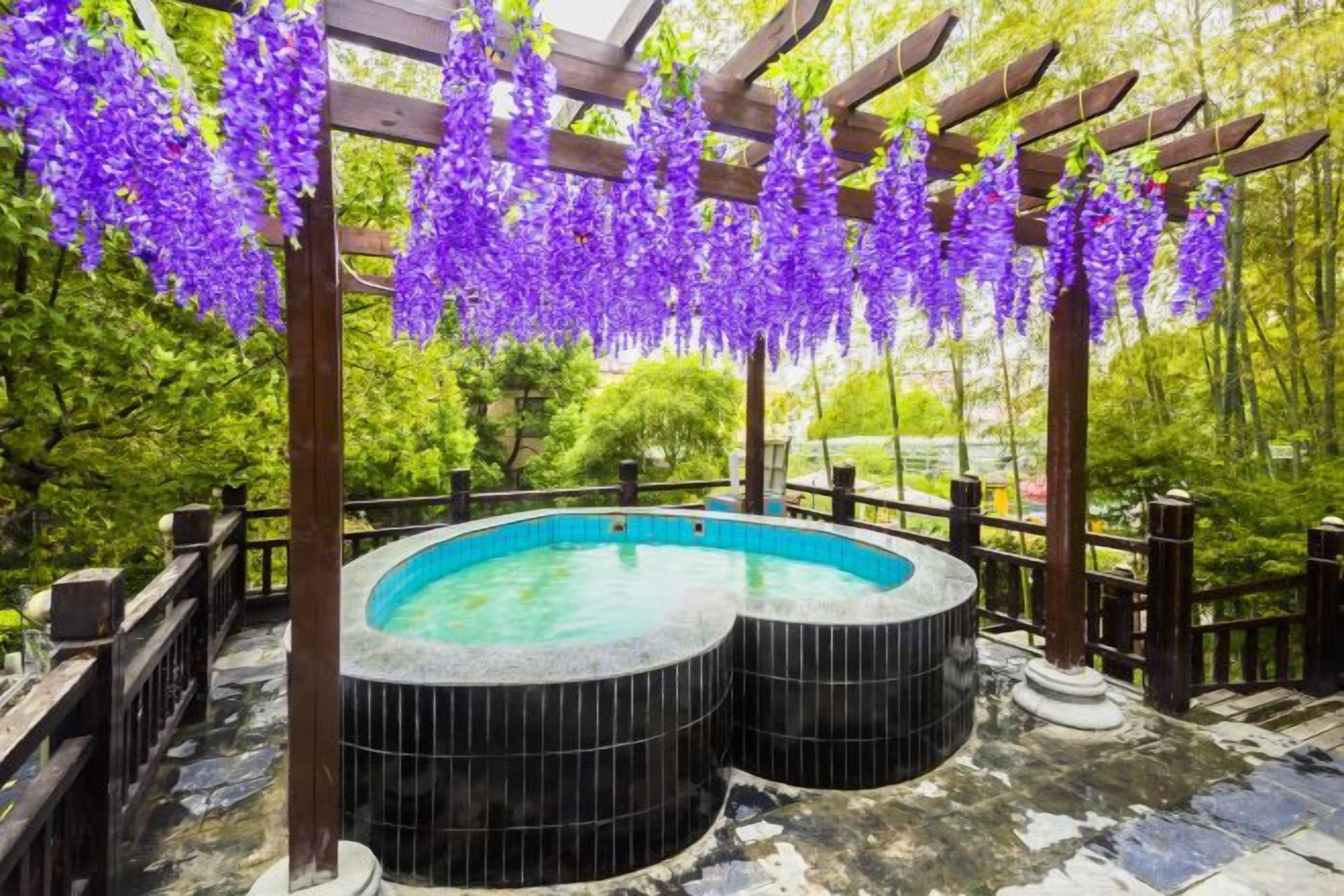 Área de hidromassagem com pergolado e flores roxas pendentes.