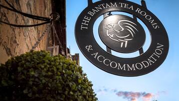 Placa de The Bantam Tea Rooms & Accommodation com um logotipo com um pássaro e ondas.