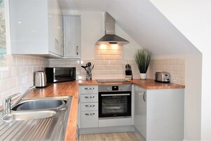 Apartamento, 1 quarto | Cozinha privada | Geladeira, micro-ondas, fogão, cooktop