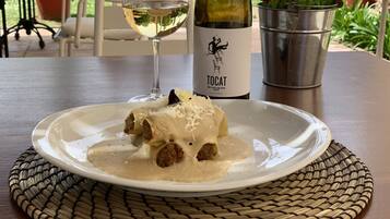 Um prato de comida com uma garrafa de vinho e um balde de metal com flores.