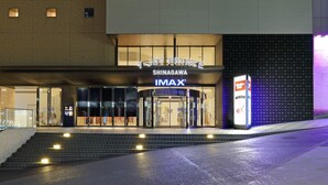 Exterior do cinema T. Joy Prince Shinagawa IMAX, com fachada moderna e um grande logotipo IMAX.