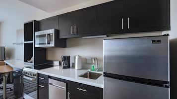 Um frigorífico/congelador grande, um micro-ondas, uma placa de cozinha