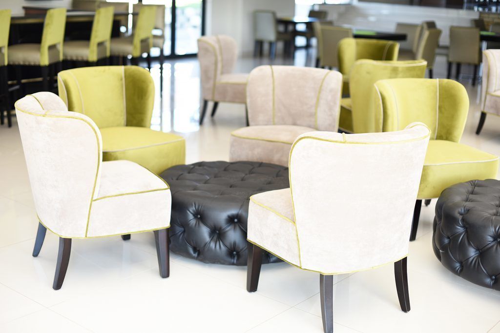 Uma área de estar com cadeiras e pufes em um interior moderno.