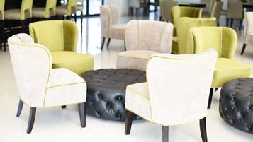 Uma área de estar com cadeiras e pufes em um interior moderno.