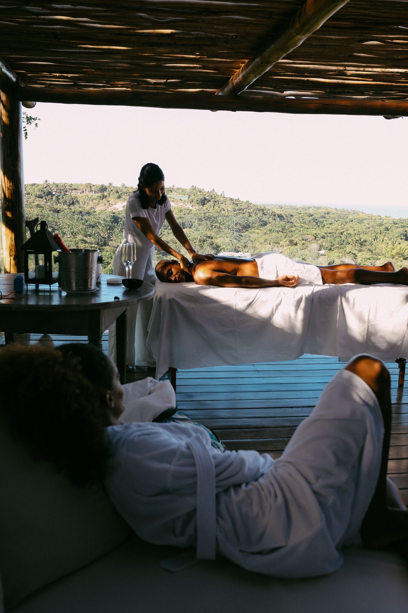 Sessão de massagem em um quarto de madeira com vista panorâmica.