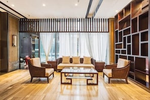 Um hall moderno com um sofá, mesa de centro e cadeiras de vime.