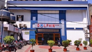 Um edifício de vários andares com uma placa que diz "DOLPHIN" no nível da rua.