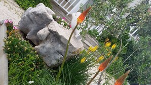 Uma área de jardim ajardinada com diversas plantas e uma estrutura de pedra.
