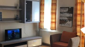 Apartamento, 2 quartos | Sala de estar | TV de ecrã plano