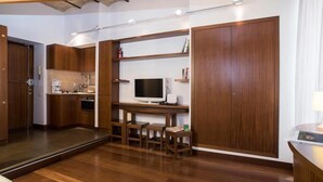 Uma cozinha moderna com armários de madeira, fogão embutido e um espaço de refeições com uma mesa e cadeiras.