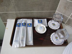 Uma bandeja com produtos de higiene, incluindo escovas de dentes, creme dental e um copo de água.