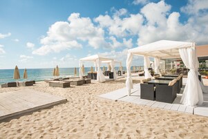Uma praia privada, espreguiçadeiras, guarda-sóis de praia 