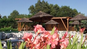 Um resort com estruturas de telhado de palha, área de estar ao ar livre e vegetação exuberante.