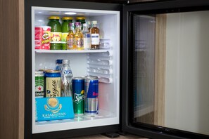Geladeira com diversas bebidas, incluindo cerveja, refrigerante e suco.