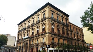 Um edifício de vários andares com estilo arquitetônico clássico, com varandas e janelas amplas.