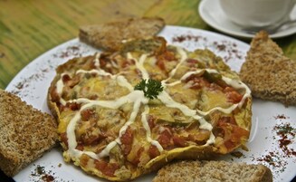 Um prato de café da manhã com uma omelete saborosa, decorado com salsa, acompanhado de fatias de pão torrado.
