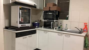 Um frigorífico no espaço comum, um micro-ondas, um forno