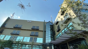 Um edifício com vários andares, design moderno, com grandes janelas e varandas.