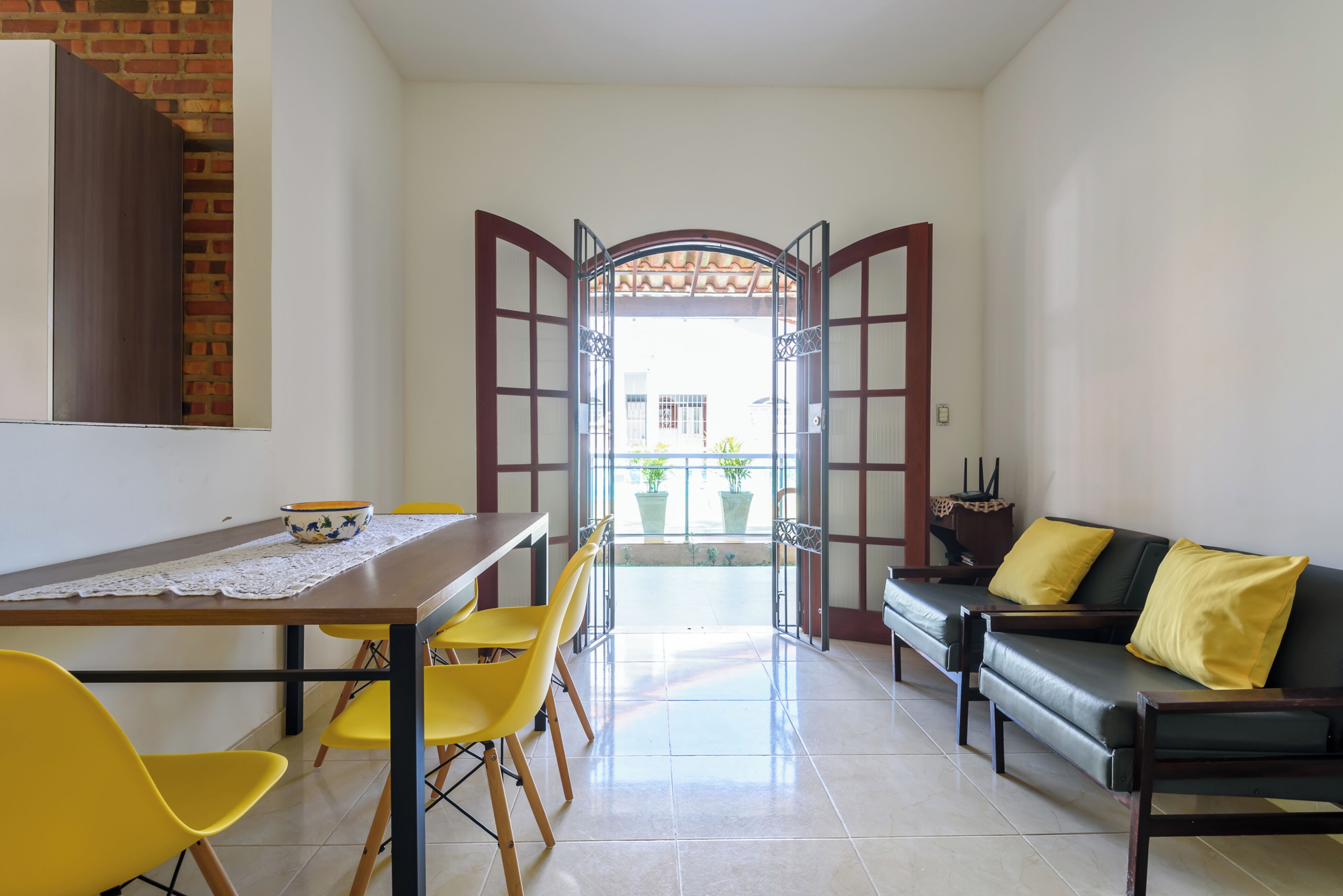 Uma sala de jantar com mesa, cadeiras e um sofá.