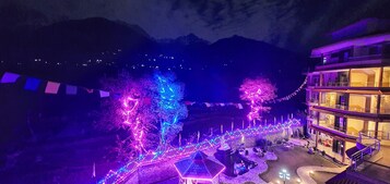 Um hotel com área de piscina, espaço para sentar ao ar livre e vista para as montanhas.