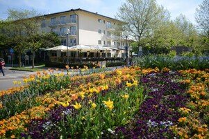 Um hotel com área externa para sentar e um jardim de flores.