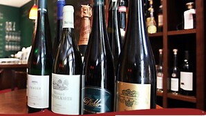 Uma área de bar com várias garrafas de vinho sobre uma mesa.