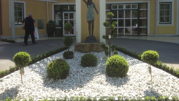 Entrada de um edifício com uma estátua, uma escadaria e uma placa com a inscrição "Evergova Residencia 2003".