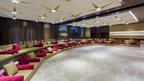 Uma sala de conferências ampla com assentos em níveis e piso de mármore polido.