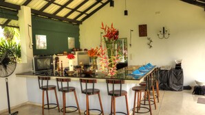 Cozinha com uma ilha grande, banquetas e um ventilador.