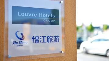 Placa do Grupo Louver Hotels com logotipos da Jin Jiang Travel.