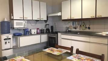 Um frigorífico, um micro-ondas, um forno, utensílios de cozinha