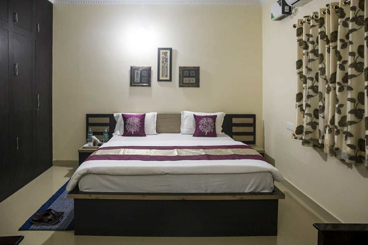 Quarto bem arrumado com cama, mesas de cabeceira e guarda-roupa.