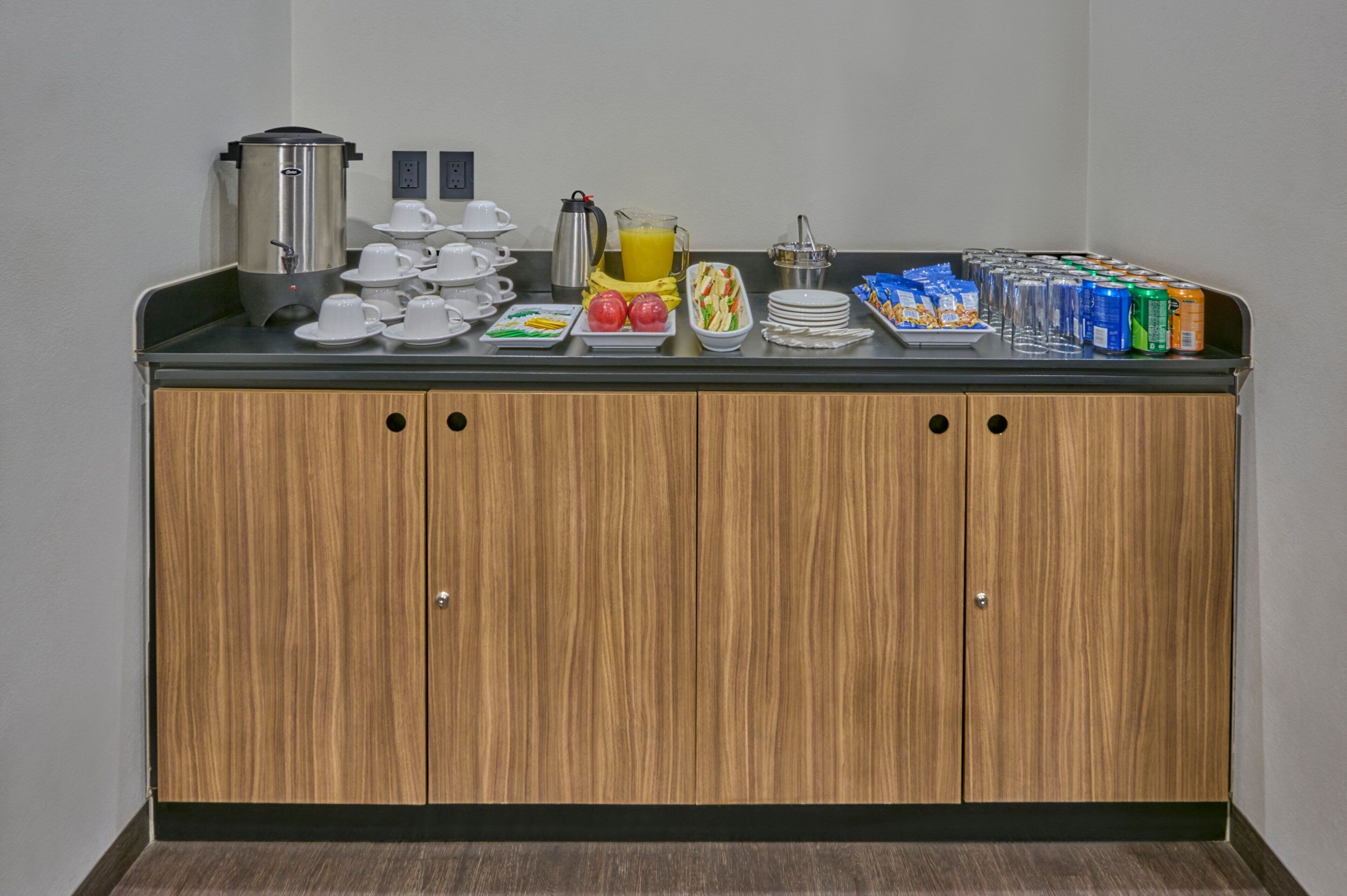 Uma mesa de pequeno-almoço com café, sumo e diversas opções de comida.