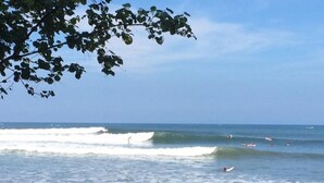 Uma praia com ondas e surfistas.