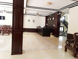 Uma área de recepção com balcão, escada e mobiliário de madeira.