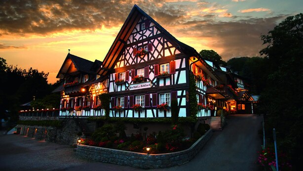 Um edifício tradicional em estilo de enxaimel com uma placa que diz 'Gäthof zum Heiligen Blut'.