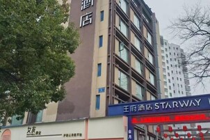 Um hotel com vários andares, um restaurante visível chamado 'STARWAY' no térreo e uma placa indicando 'HOTEL' na fachada.