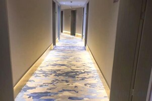 Um corredor com piso estampado que leva a uma porta.