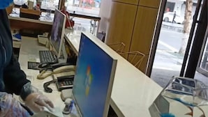Balcão de atendimento com computadores, telefone e aquário.