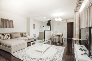 Uma sala de estar moderna com sofá, mesa de centro e área de jantar.