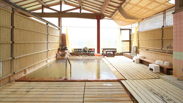 Um onsen japonês tradicional com pisos de madeira e balaústres de bambu.