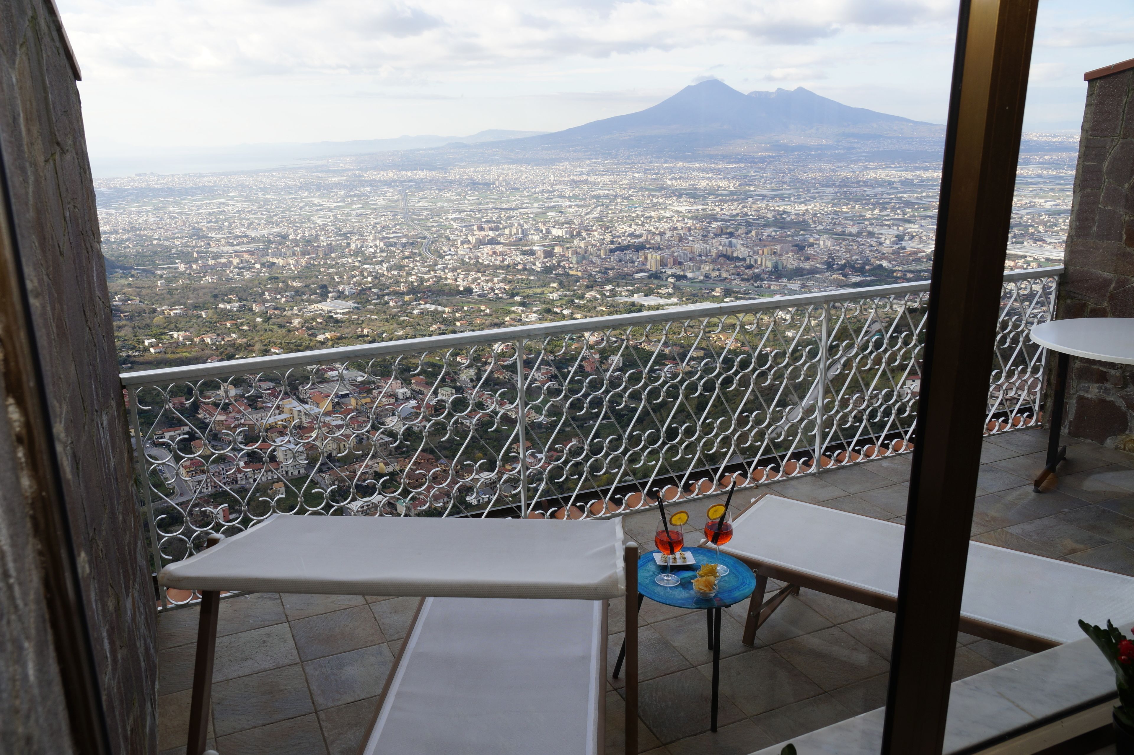 Uma varanda com vista para uma paisagem urbana e uma montanha.