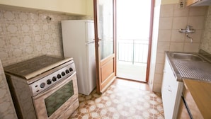 Cozinha compacta com fogão, geladeira e pia.