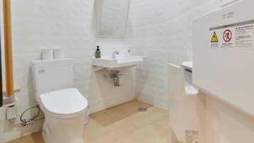 Casa de banho moderna com sanita, lavatório e espelho.