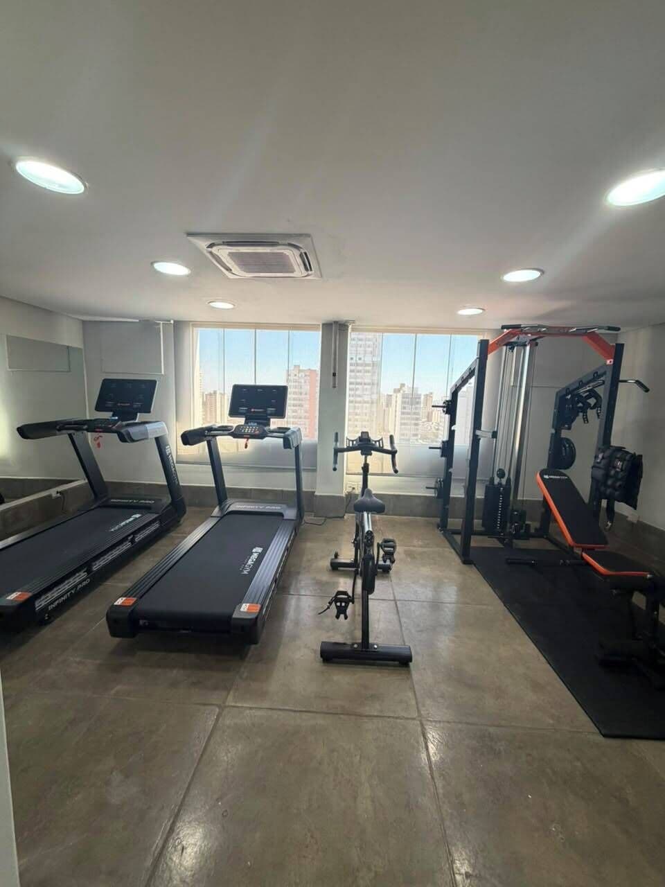 Academia com esteiras, bicicleta ergométrica e área de musculação.